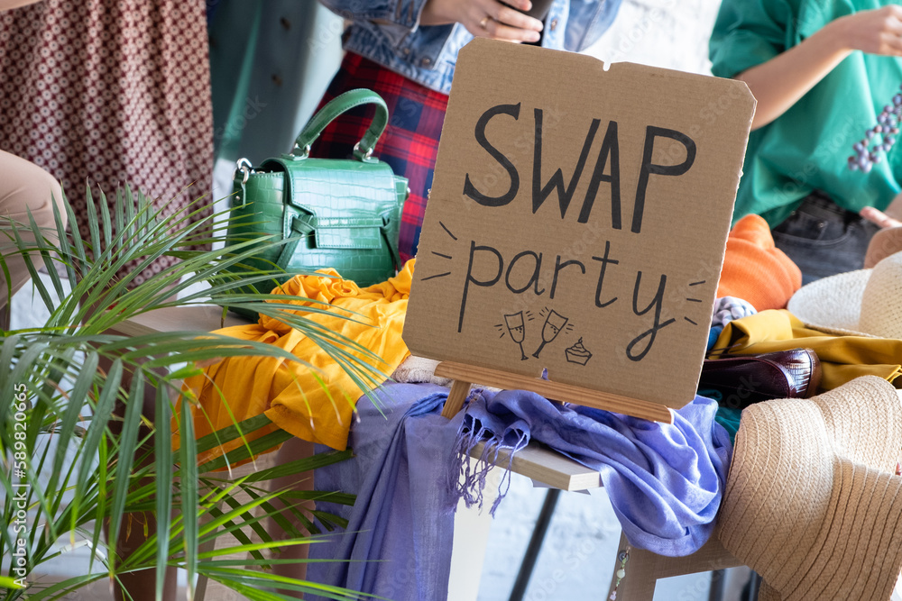 Young women at swap party. Choose casual clothes, shoes, hats, bags ...