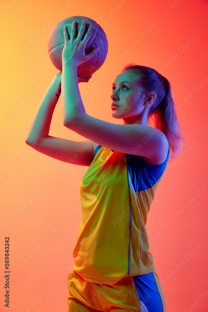 Young concentrated girl, female basketball player in uniform, posing ...
