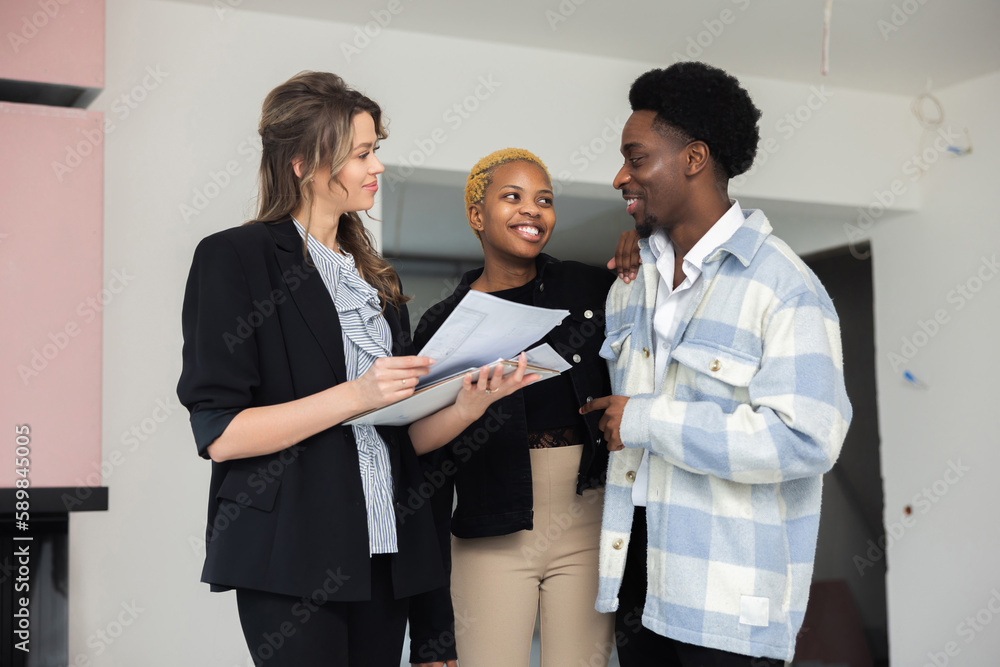 The blonde real estate agent attentively listens to the African couple ... The blonde real estate agent attentively listens to the African couple ...