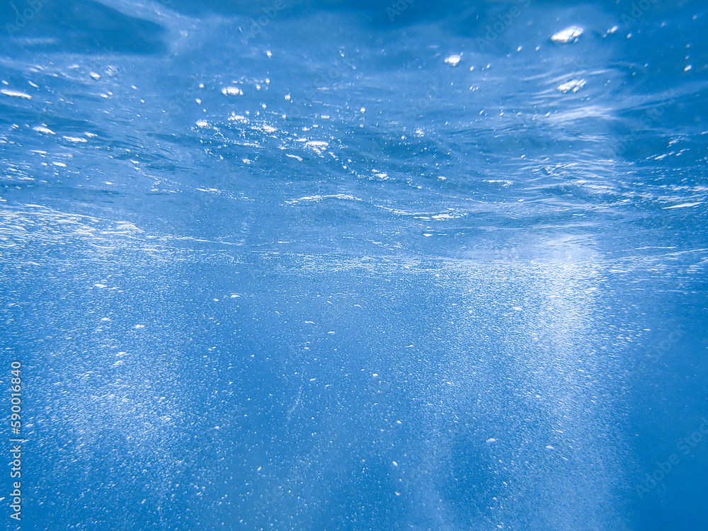 Bubbles under the sea in the crystal clear green sea water ...