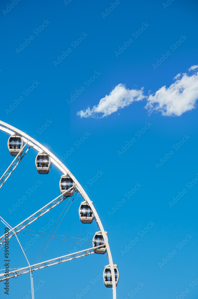 Part of ferris wheel against a blue sky background. Ferris wheel with ...