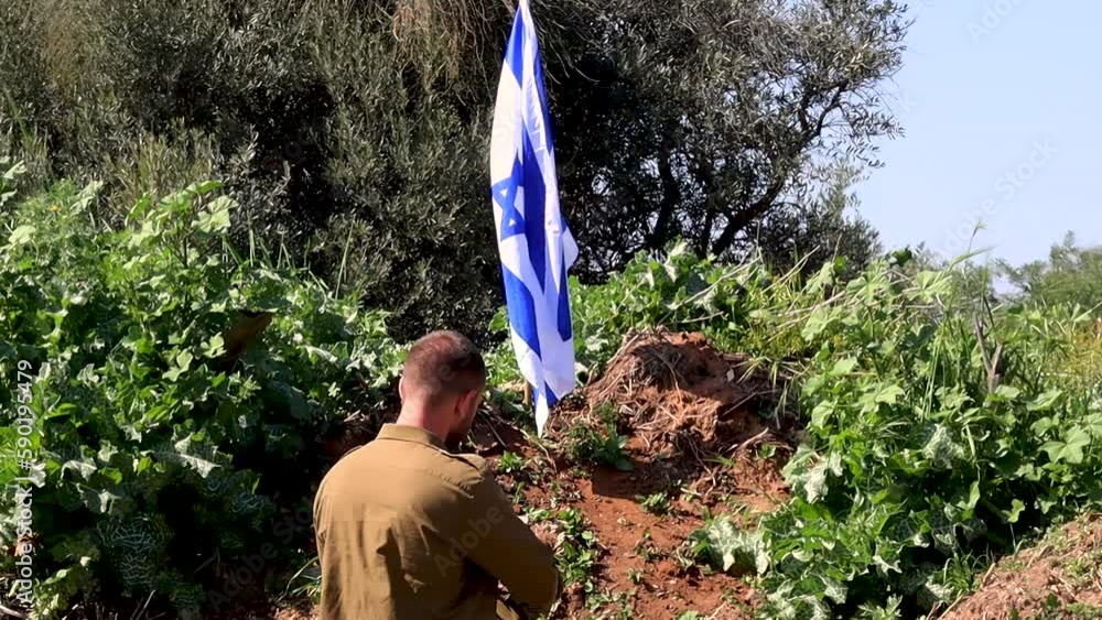 Israeli soldier puts on an army beret and salutes the flag of Israel ...