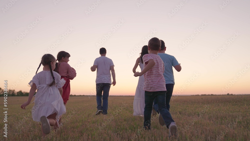 Children, child, together with their parents run in park, sunset. Dad ...