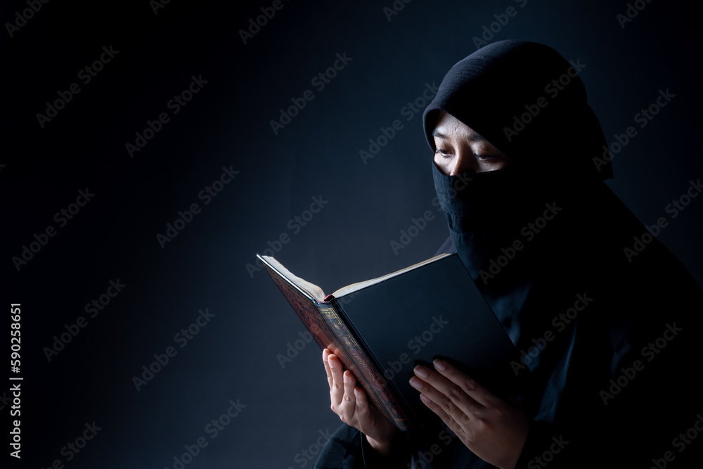 Foto de Portrait Asian Muslim woman standing and reading the Quran and ...