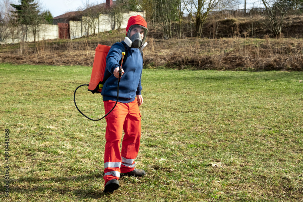 Man gardener wearing protective clothing and full face respirator mask ...