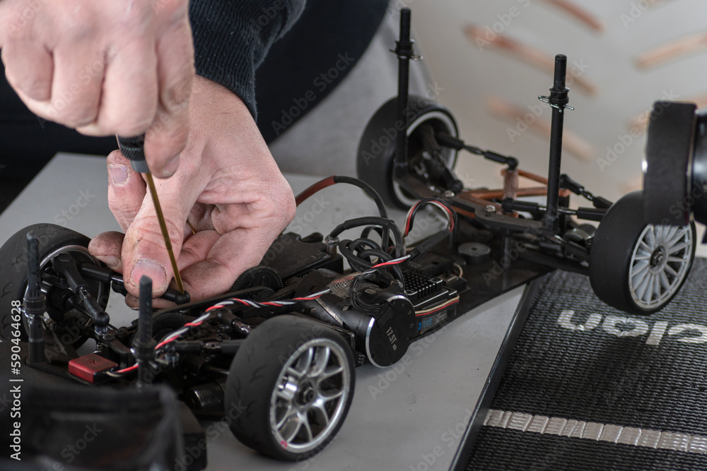 RC radio control model car chassis in electric repair, a man uses a ...