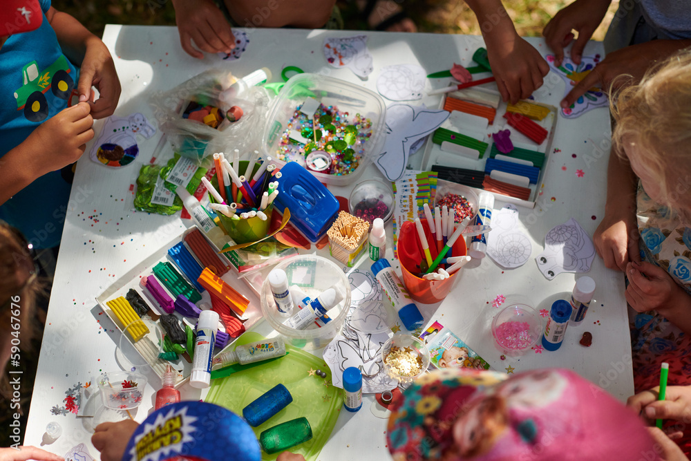 Children paper crafting with parents in outdoor children party ...