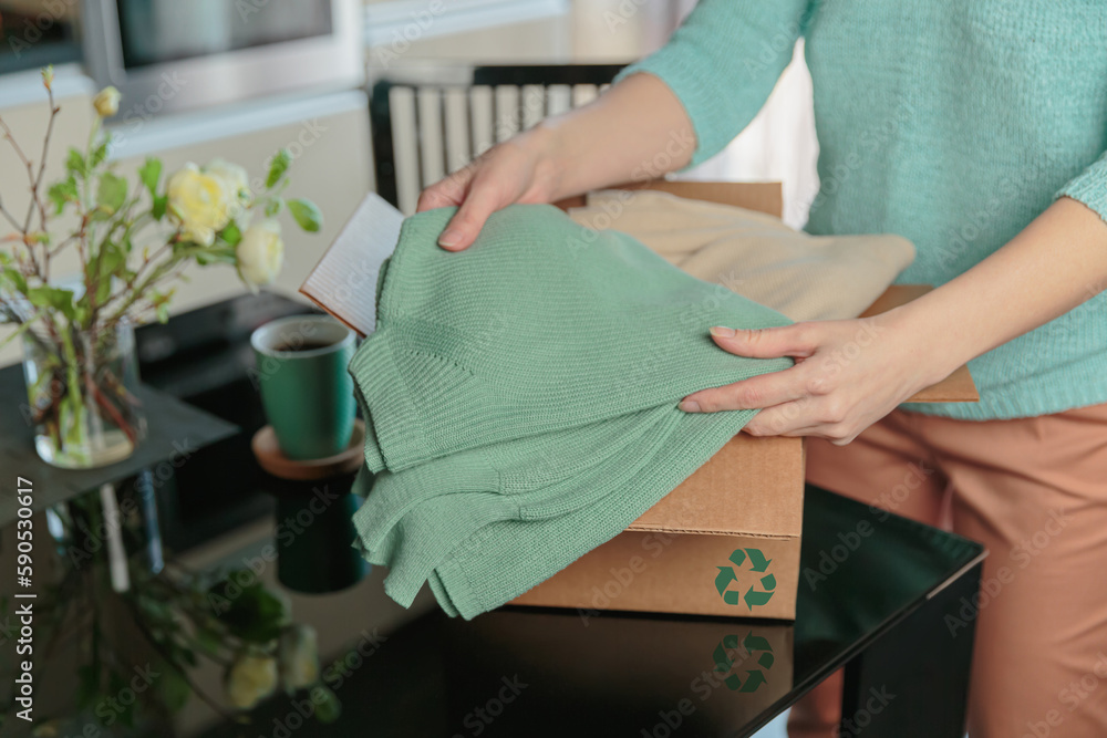 Woman packing box with used wardrobe for reuse. Reusing, recycling ...
