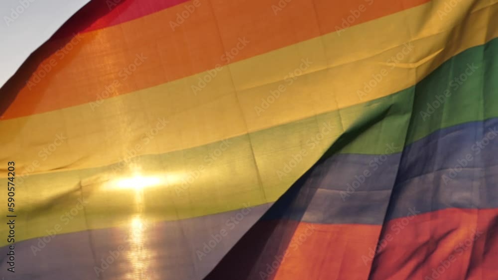 Vidéo Stock LGBT flag on sunset background by the lake. LGBT gay pride ...
