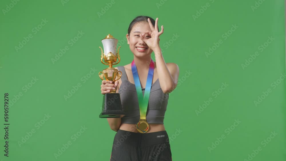 Asian Woman With A Gold Medal And Trophy Showing Okay Hand Sign Over ...