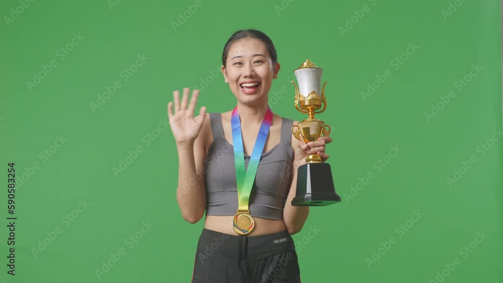 Asian Woman With A Gold Medal And Trophy Waving Her Hand And Smiling To ...
