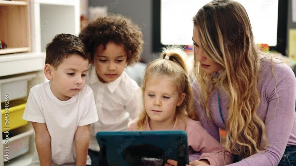 Woman and group of kids having lesson using touchpad at kindergarten ...
