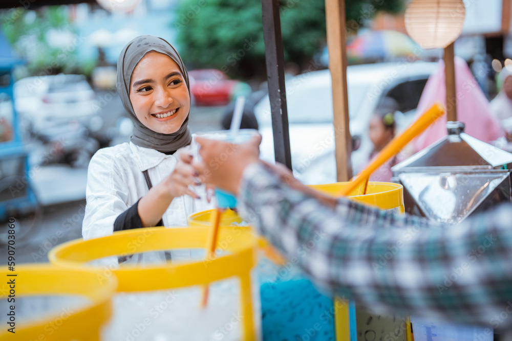 man sells colorful drink and juice in a jar to his female customer ...