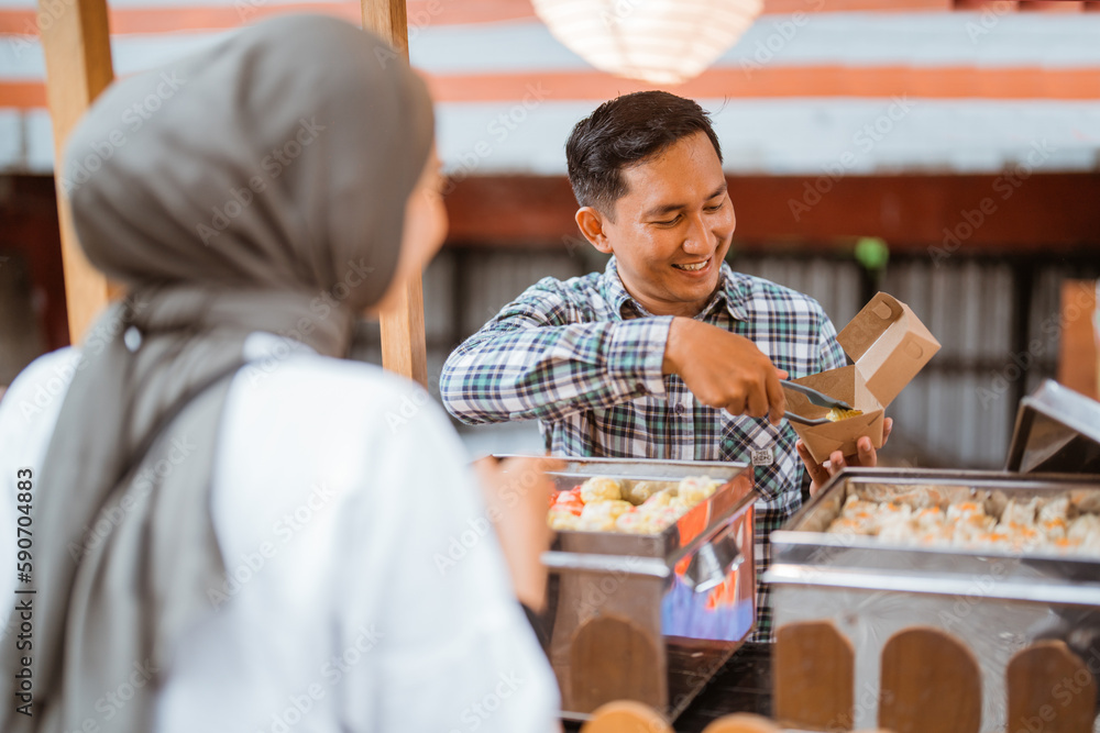 man sells various kinds of dumpling food with a cart on the side of the ...