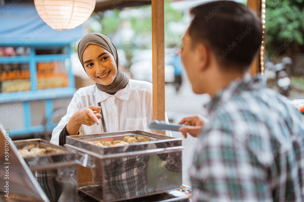 man sells various kinds of dumpling food with a cart on the side of the ...