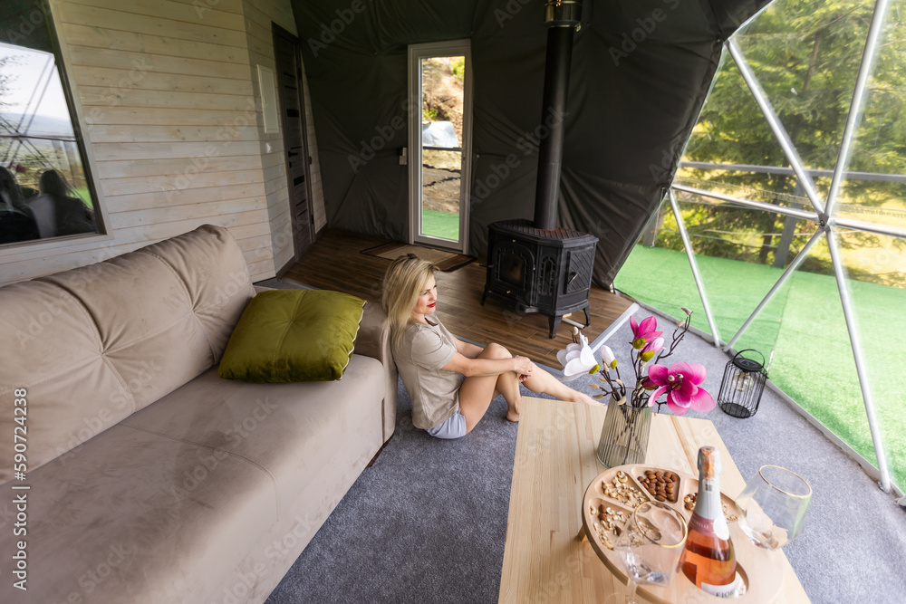 woman in interior of modern luxury glamping tent camp. Eco design ...