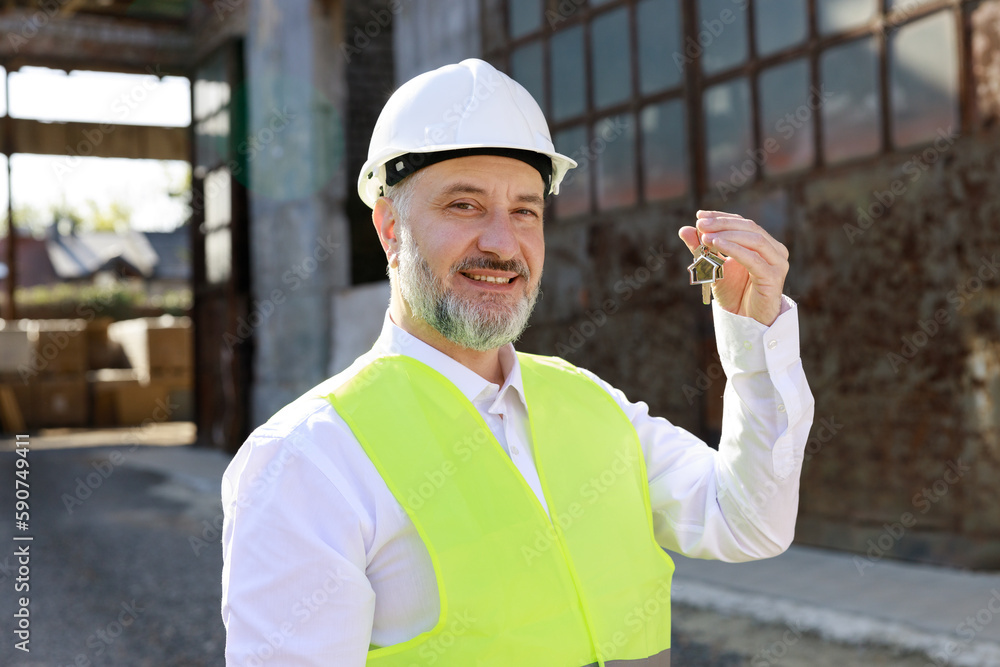 Portrait of smiling foreman holding keys from new home. Caucasian ...