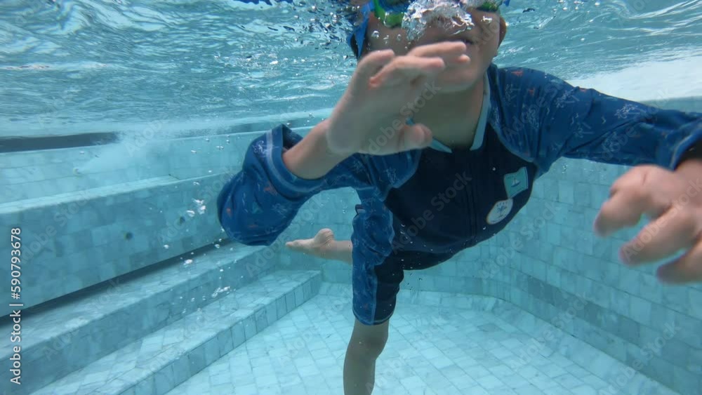 a boy enjoying summer vacation, underwater view of happy child diving ...