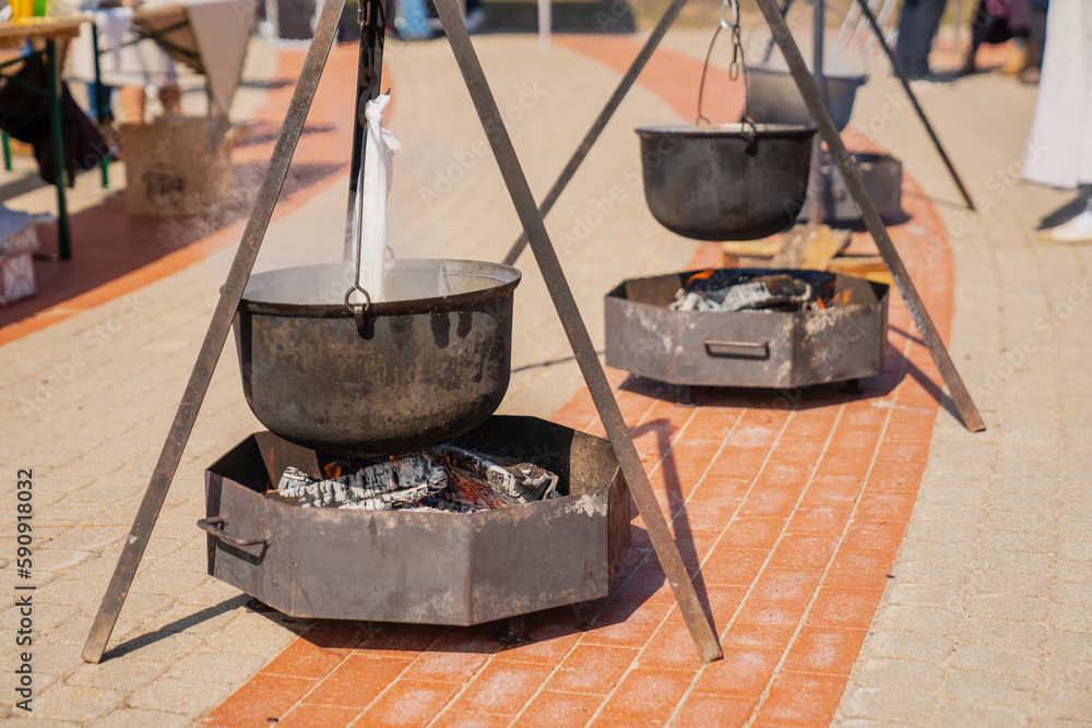 Big picnic cooking pots over grills on city festival on pavement ...