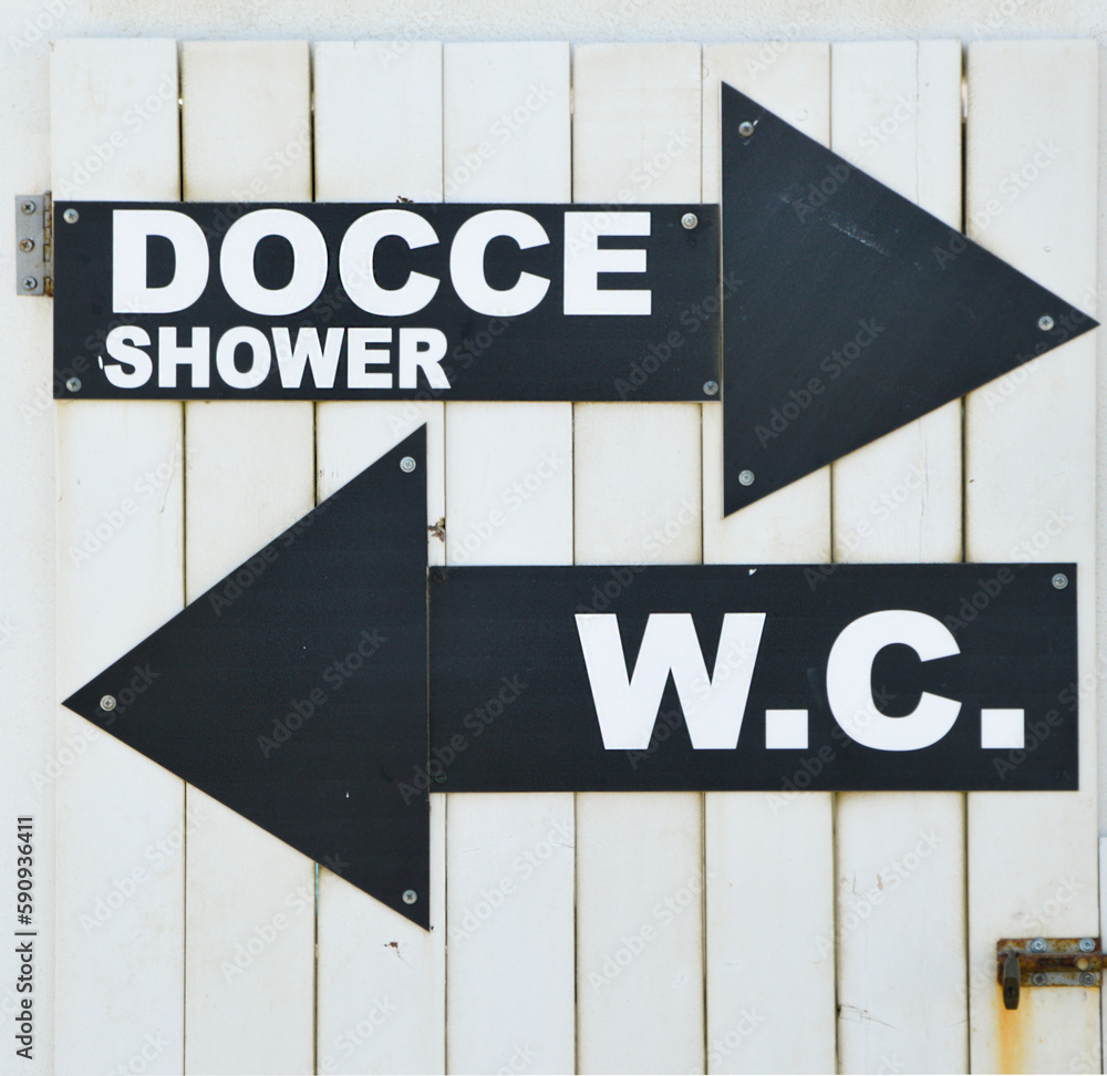 Arrow sign on a white wooden wall indicating the direction of the ...