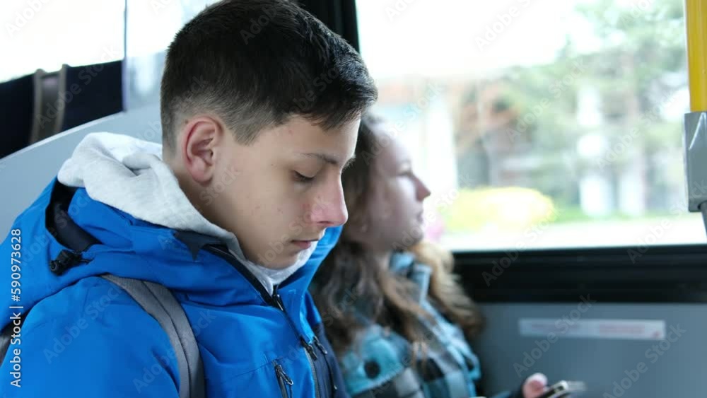 two teenagers in blue clothes sit on a bus Canada Vancouver hoods ...