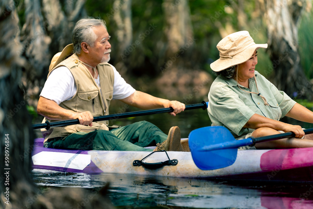 Asian senior couple kayaking together in the lake at mangrove forest on ...