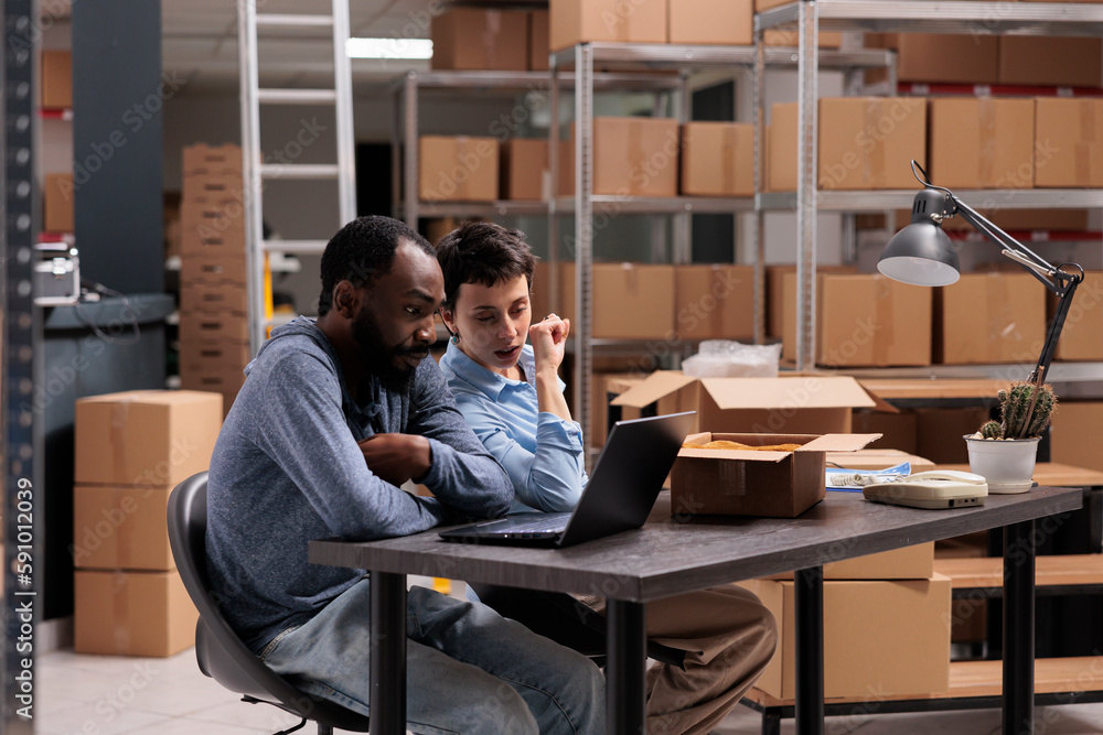 Storehouse workers checking orders logistics on laptop computer before ...