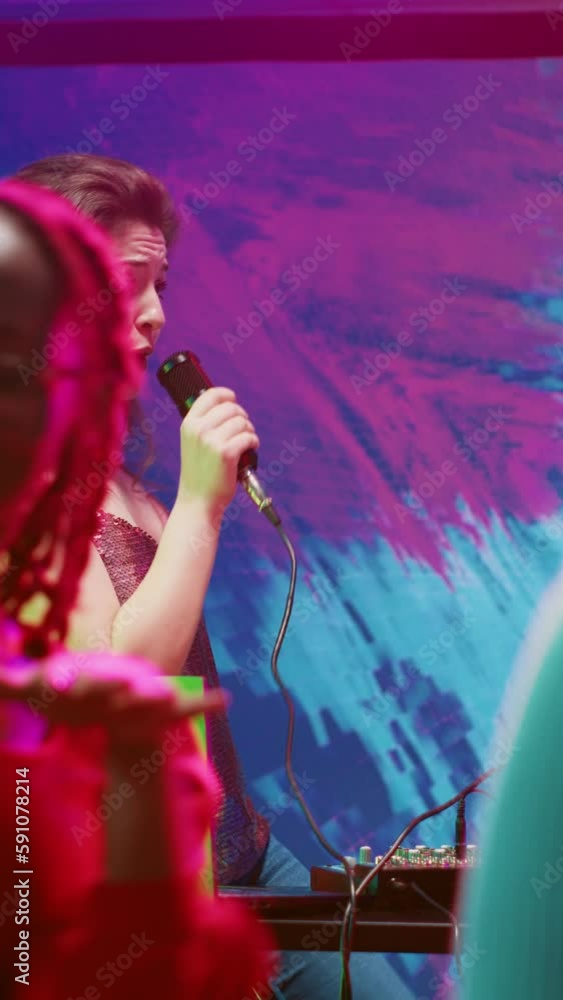 Vertical video: Young woman singing songs with DJ, creating fun ...