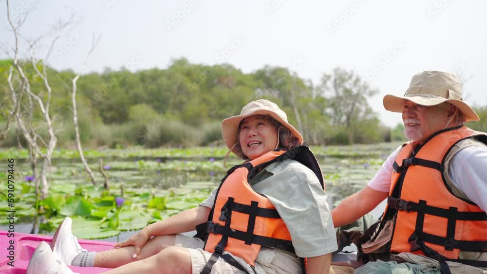 Asian senior couple kayaking together in the lake at mangrove forest on ...