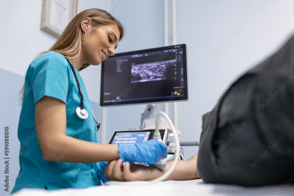 Female doctor doing ultrasound examination of patient's arm veins in ...
