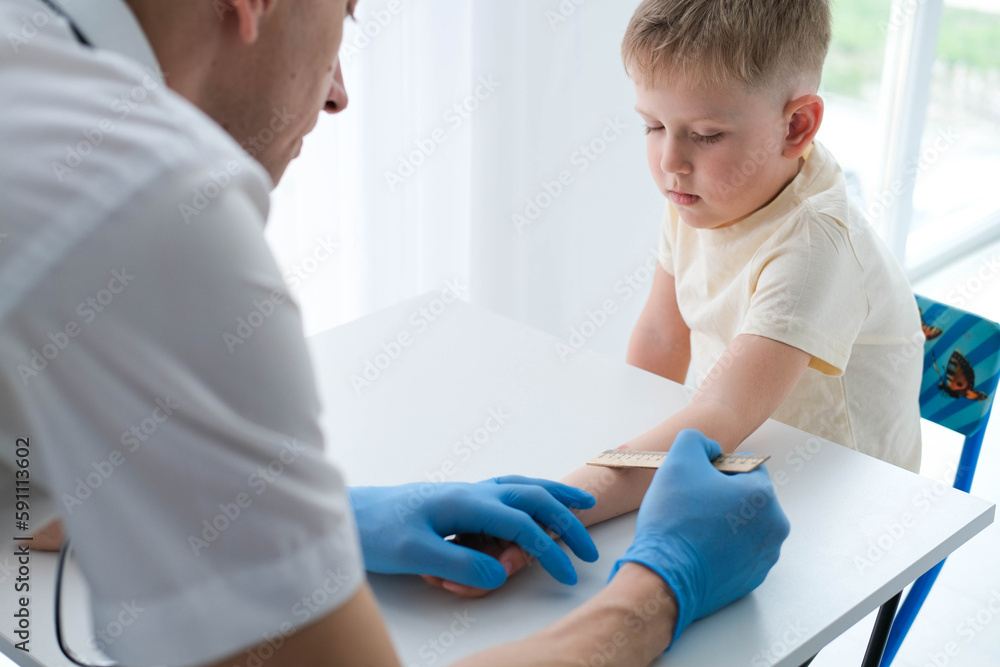 A male doctor makes an important Mantoux test on a child. The doctor ...