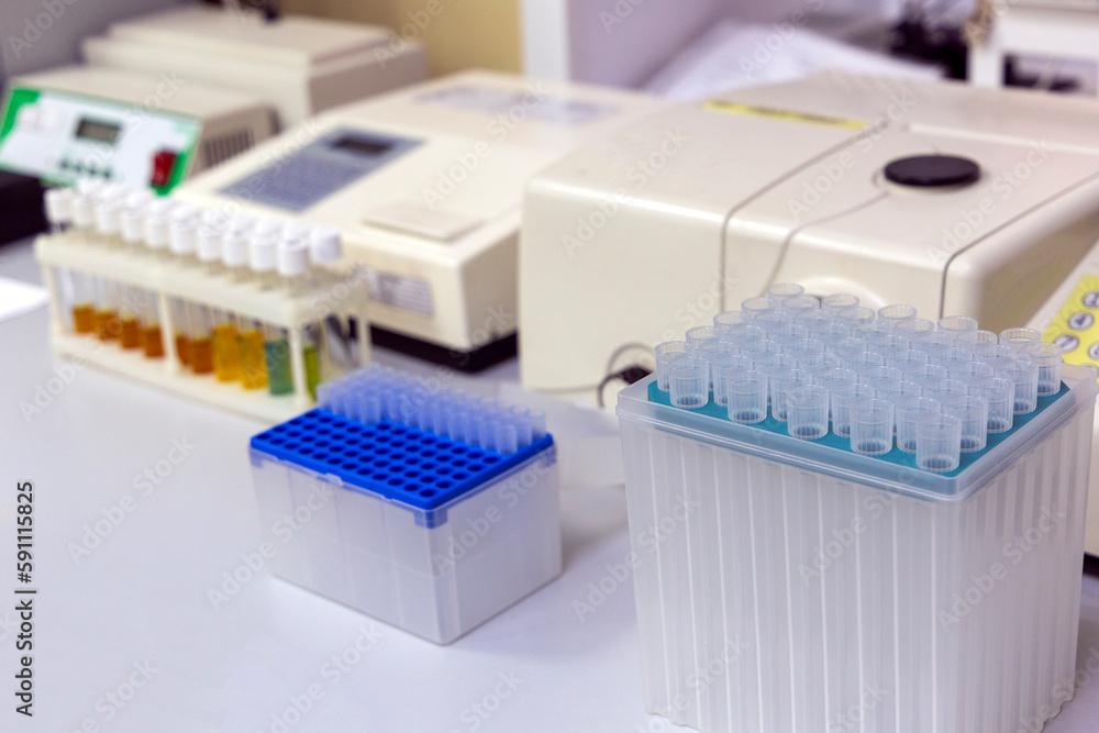 laboratory table with multi-colored reagent vials in the stand ...