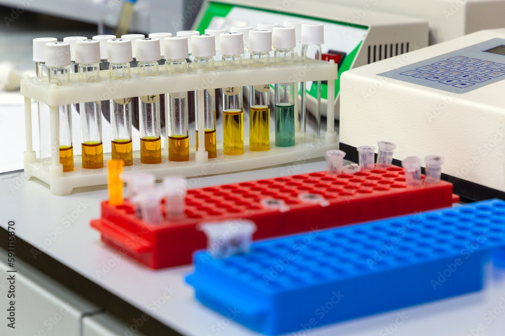 Foto de laboratory table with multi-colored reagent vials in the stand ...