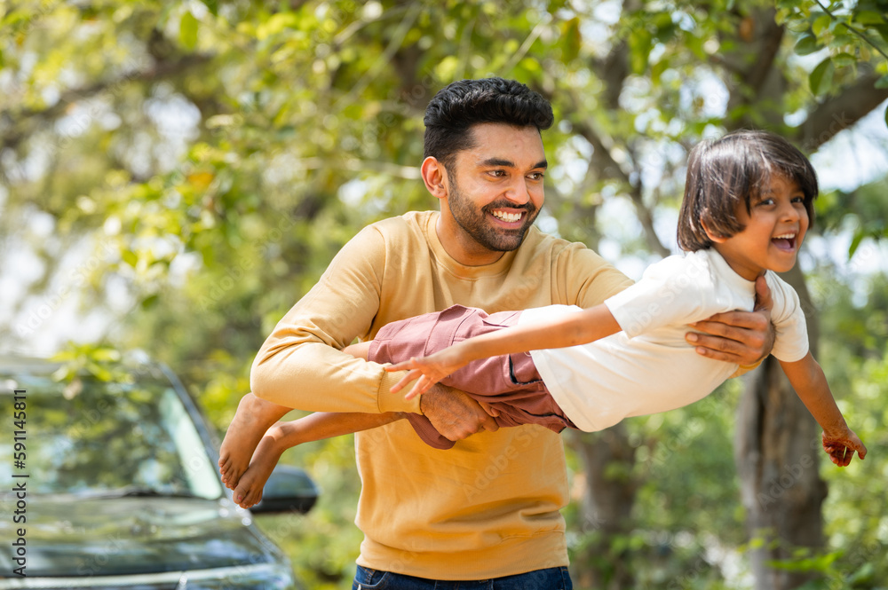 Happy young father playing by holding daughter while kid flying like a ...