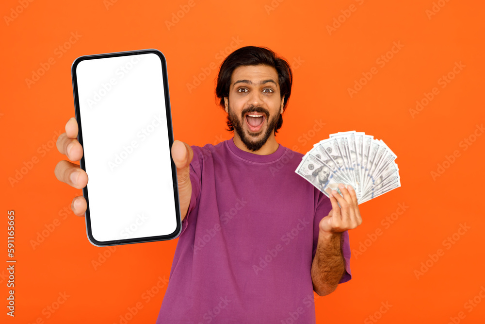 Excited indian man showing cell phone and cash dollar banknotes Stock ...