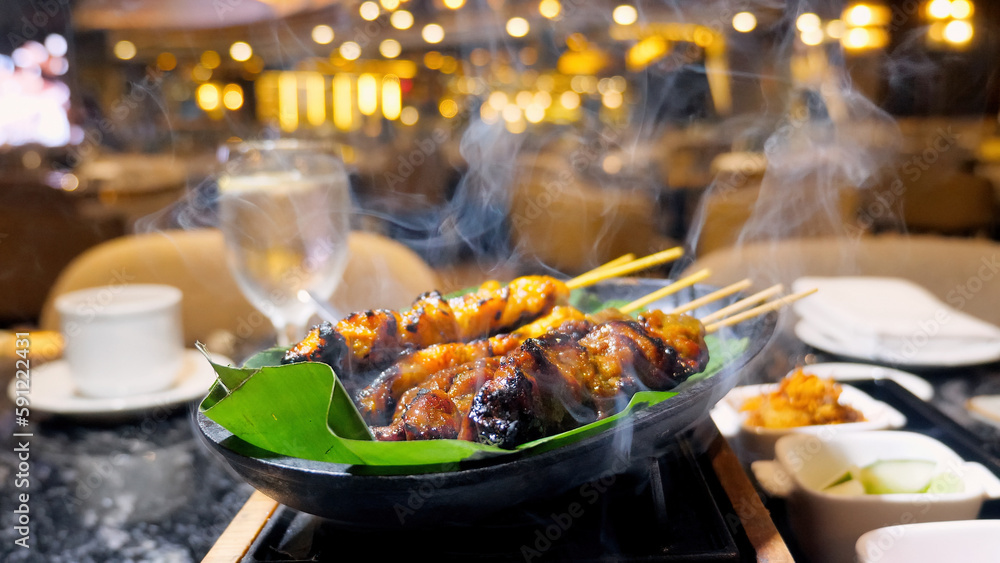 Satay chicken skewers cooked on the grill with smoke. Delicious ...