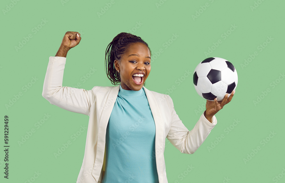 Happy excited young black woman with football chanting loudly standing ...