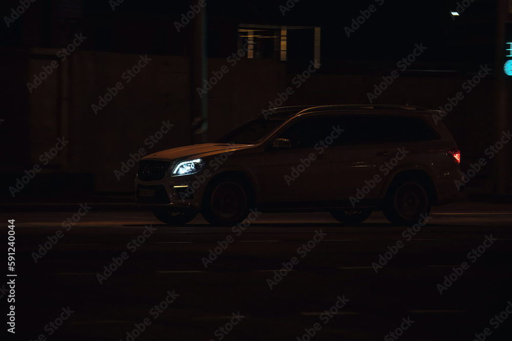 car moving on street at night. Mercedes GLS in motion on dark city road ...