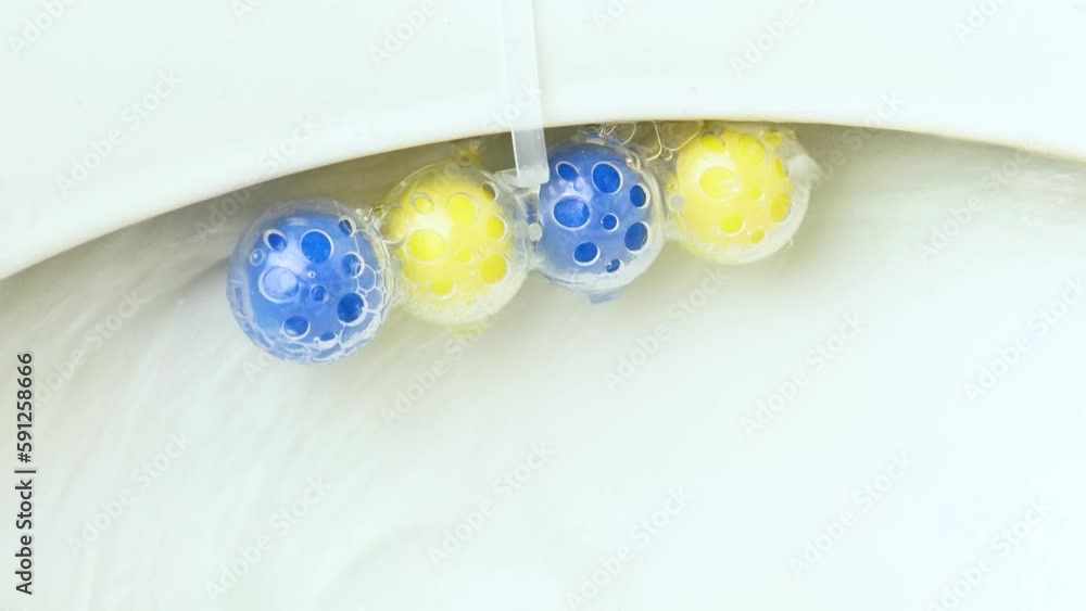 Toilet bowl water flush fresh cleaner balls hanging over the rim. 4K WC ...