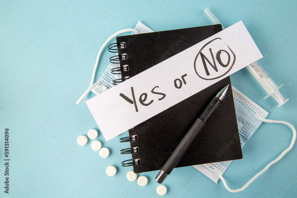 top view black copybook with pills injection and yes or no note on blue ...