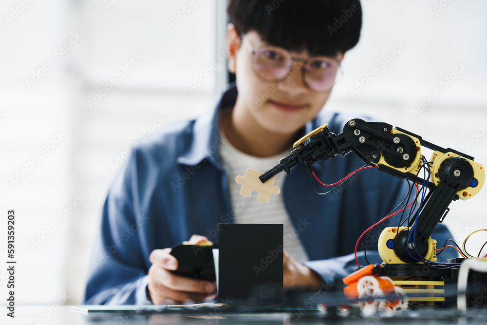 Asian teenager students doing or playing robot arm and robotic cars ...
