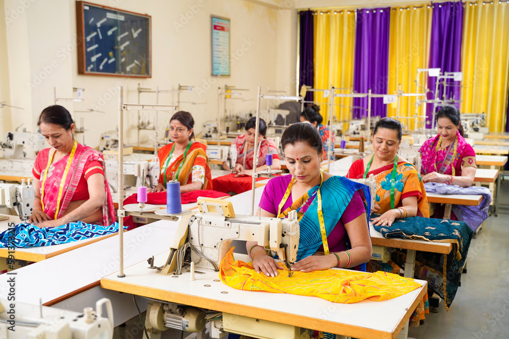 Foto de Indian women group working on sewing machine at textile factory ...