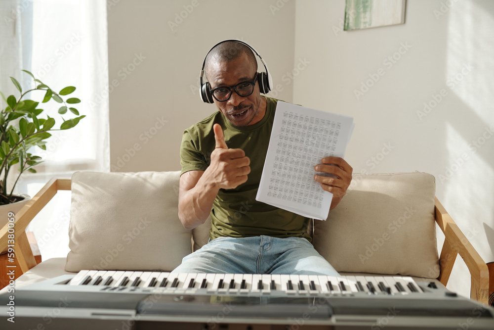 Music teacher holding music notes and showing thumbs-up Stock Photo ...