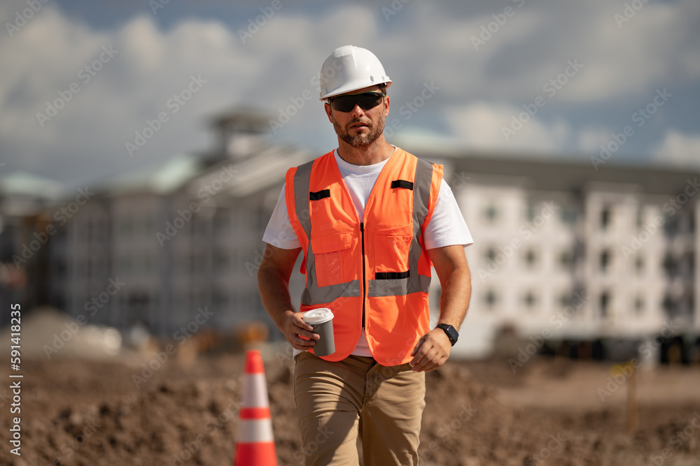 Worker in building uniform on buildings construction background ...
