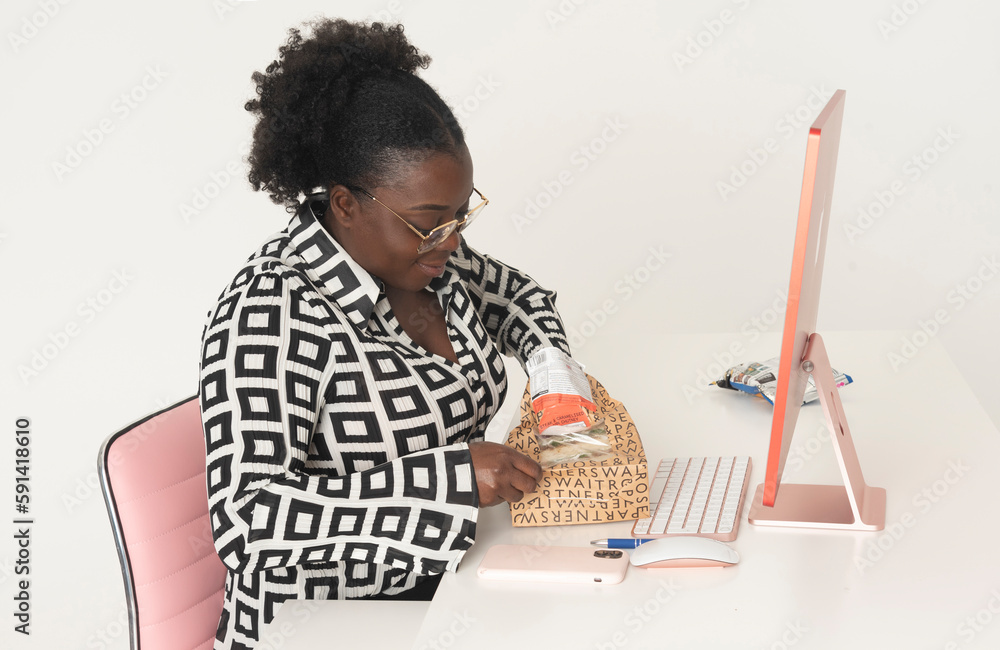 England, UK. 2023. Black office worker having a sandwich for lunch ...