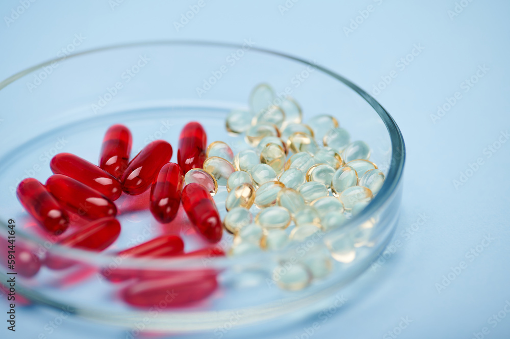Red and gold color translucent gel capsules with fat solubles vitamins ...