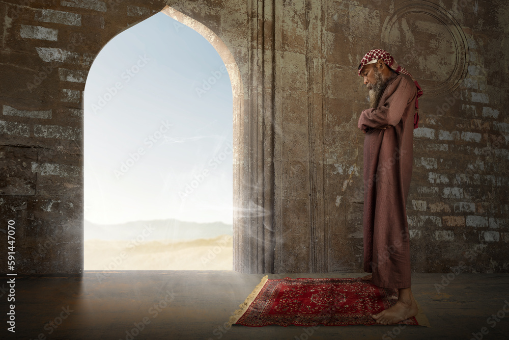 Muslim man with a beard wearing keffiyeh with agal in praying position ...