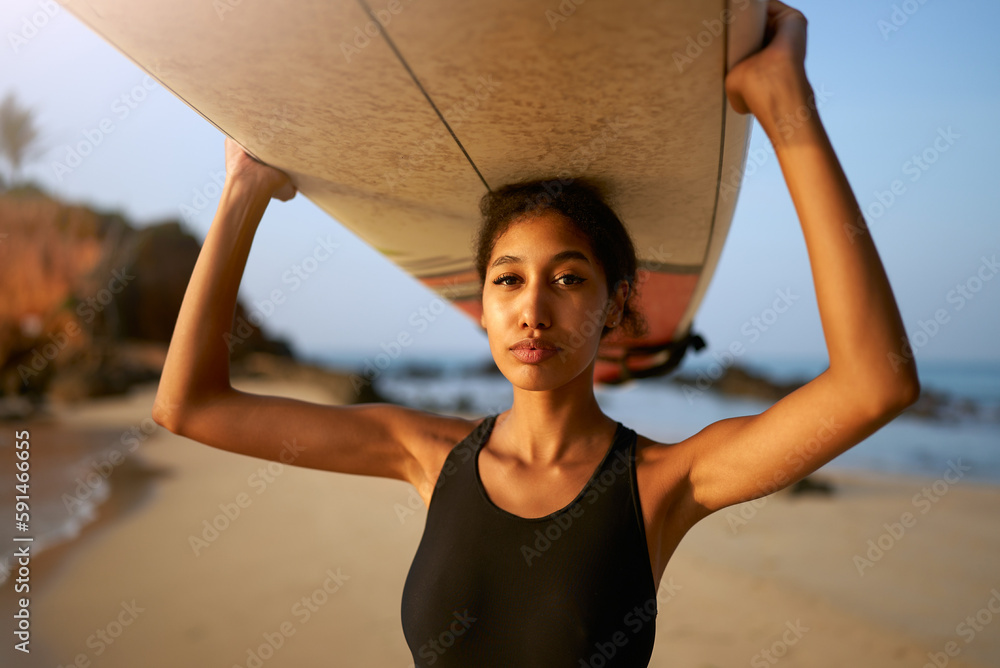 African american woman standing with surfboard on head on ocean beach ...