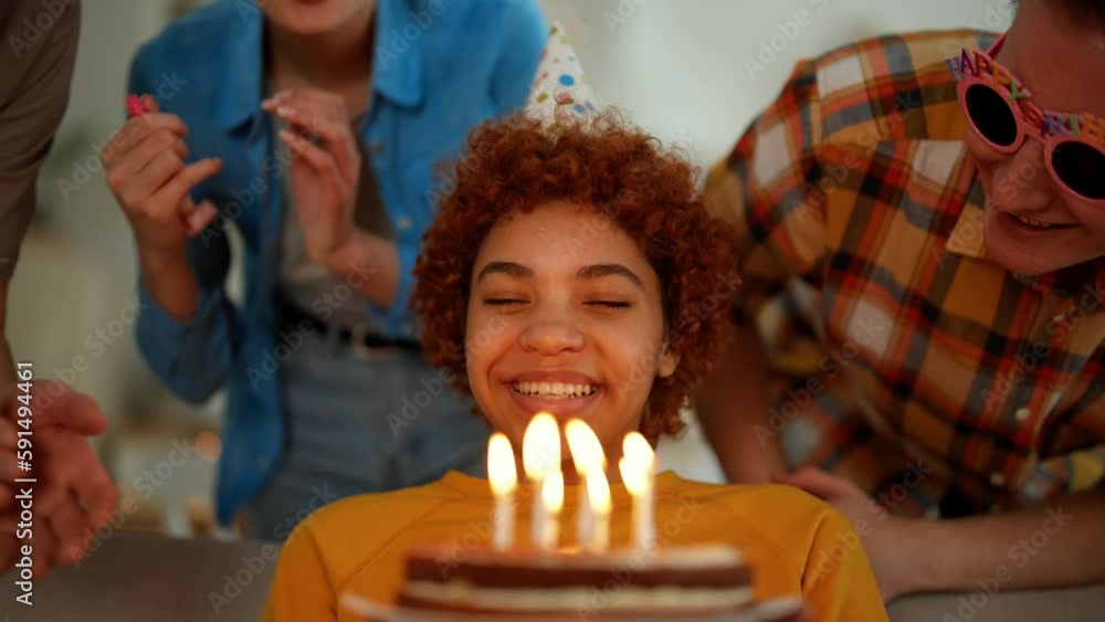 African american girl celebrates birthday with friends blows candles on ...
