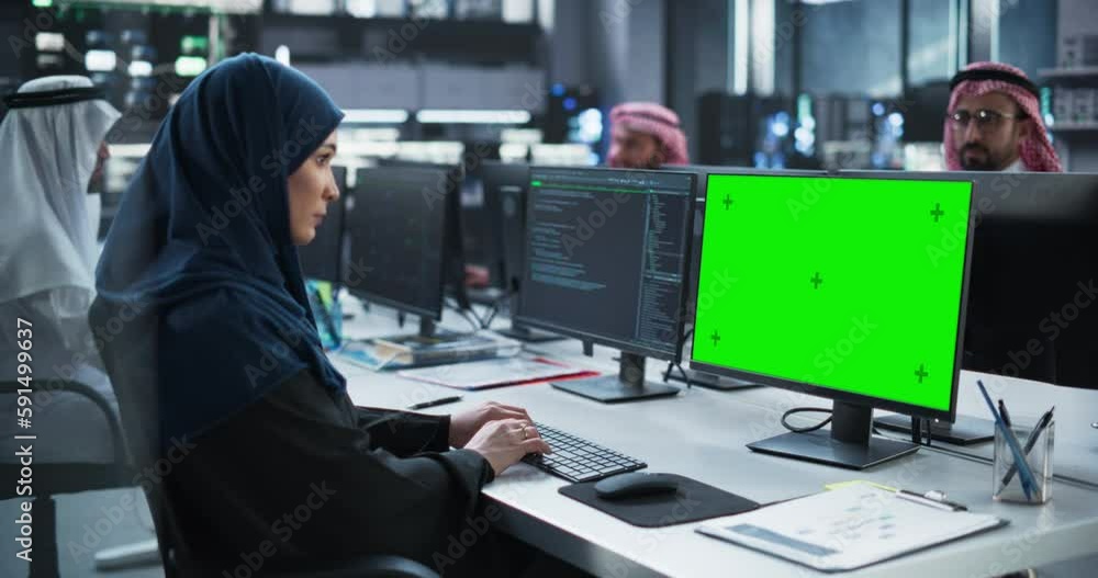Arab Female Software Developer Working on Desktop Computer with Green Screen Mock Up Display ...